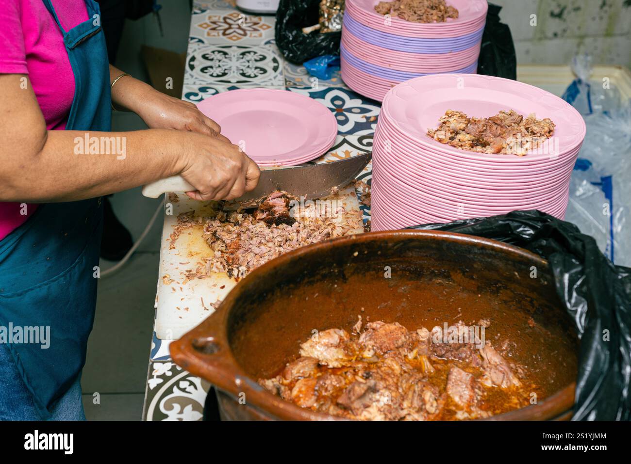 Unrecognizable woman serving meat on a plate during a Mexican party ...