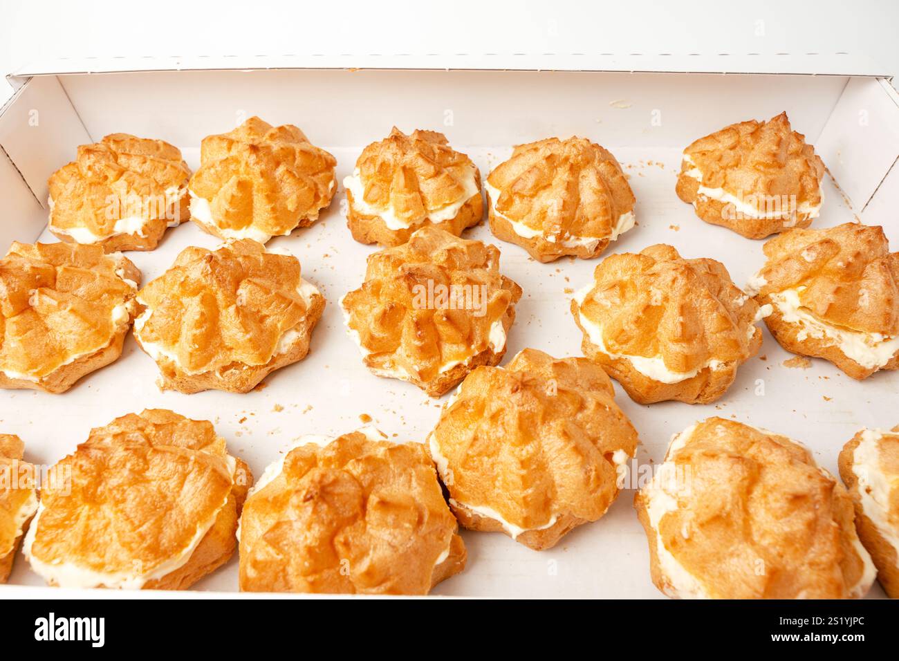 A tray of pastries with a white box underneath. The pastries are small ...