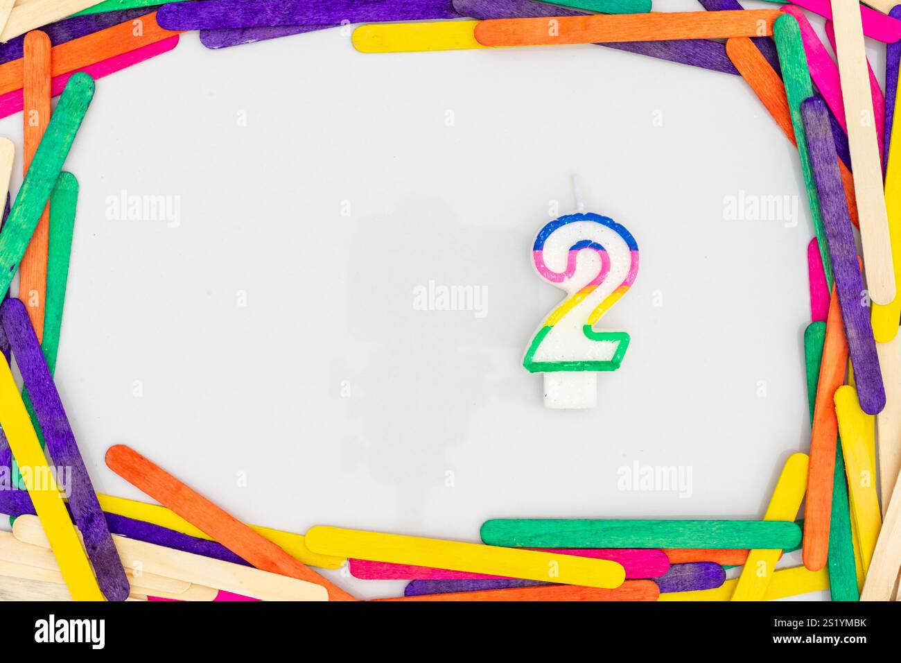 Two numerical number shape rainbow colors candle in a colorful wooden ...