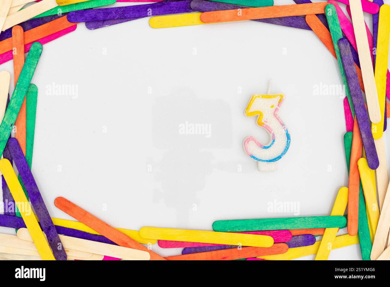 Three numerical number shape rainbow colors candle in a colorful wooden ...