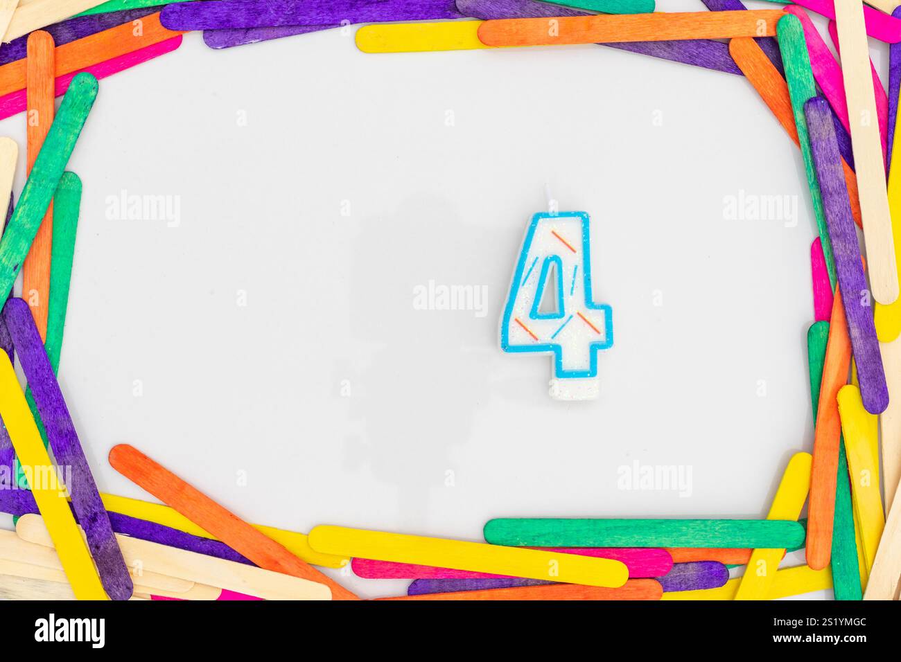 Four numerical number shape rainbow colors candle in a colorful wooden ...