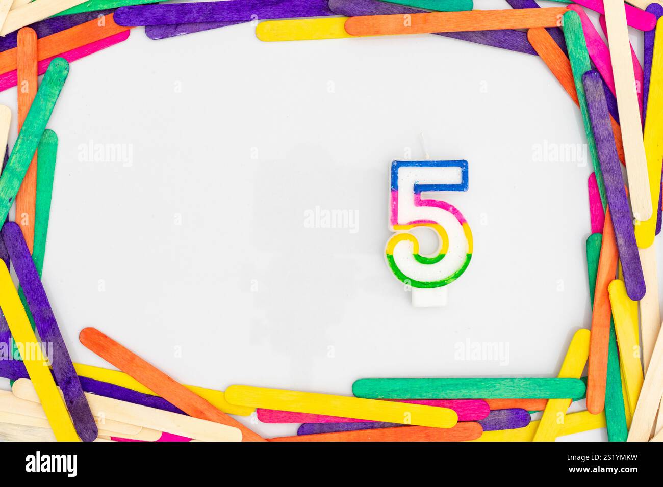 Five numerical number shape rainbow colors candle in a colorful wooden ...