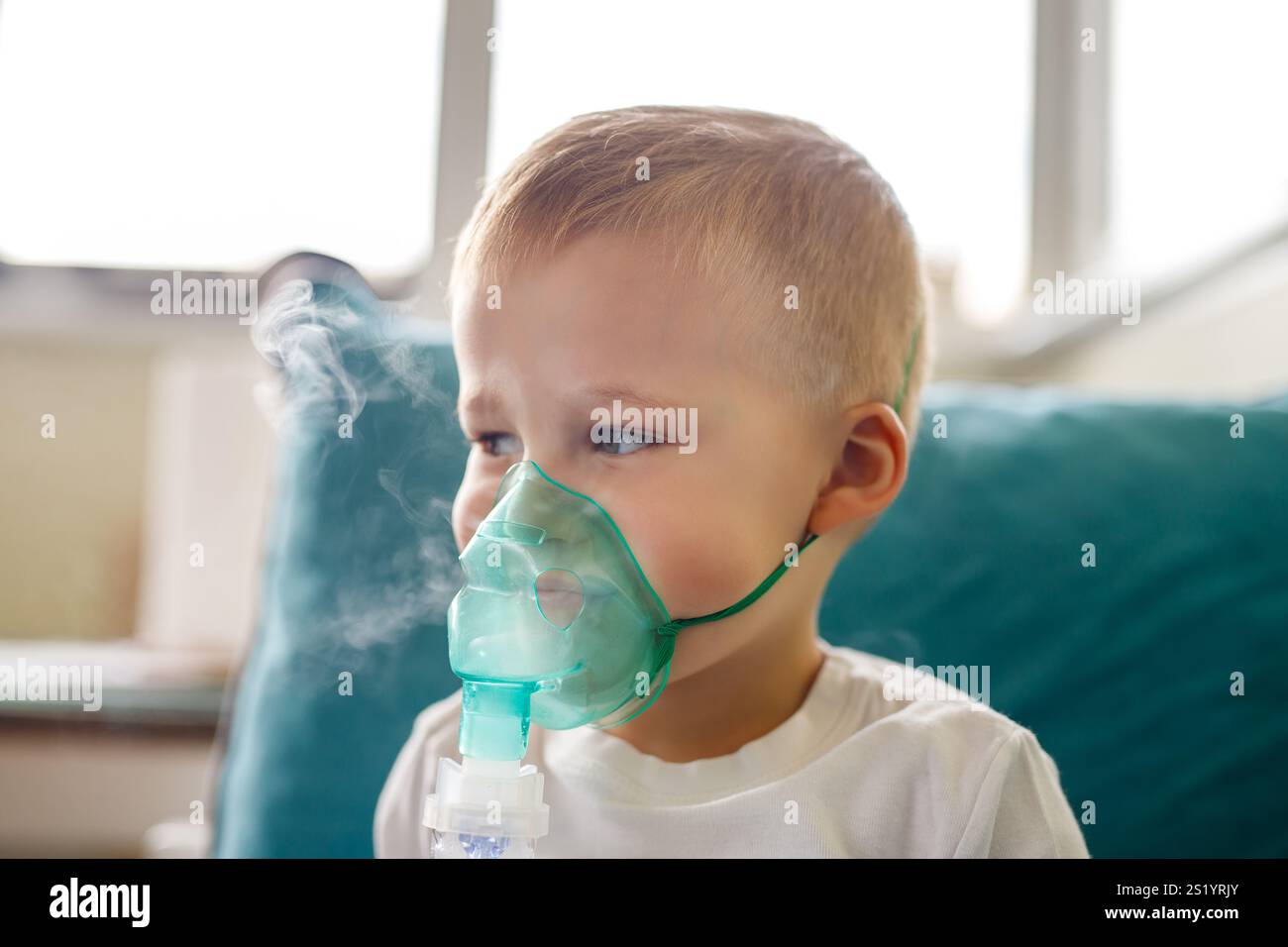 Cute little kid boy wear use medical nebulizer mask inhaling steam ...
