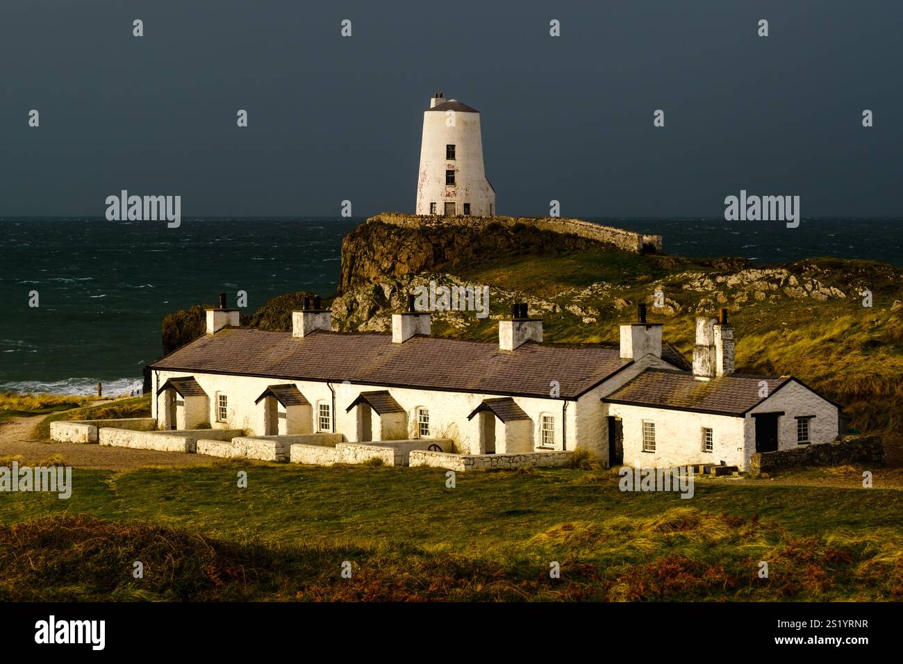 Twr Mawr Lighthouse & Pilots Cottages briefly illuminated by the rising ...