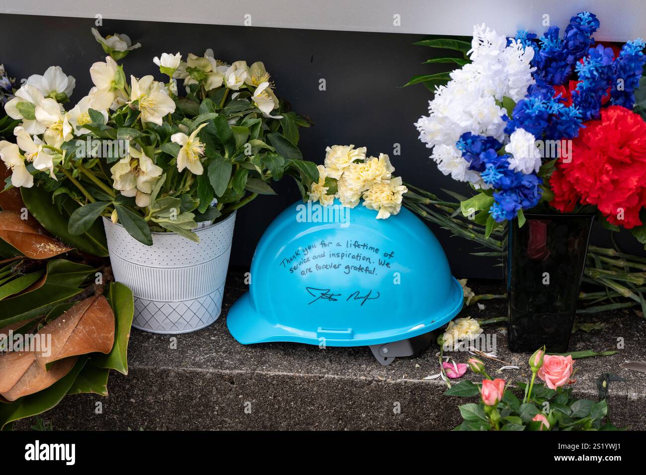 Flowers and mementos are seen near the entrance as former President ...