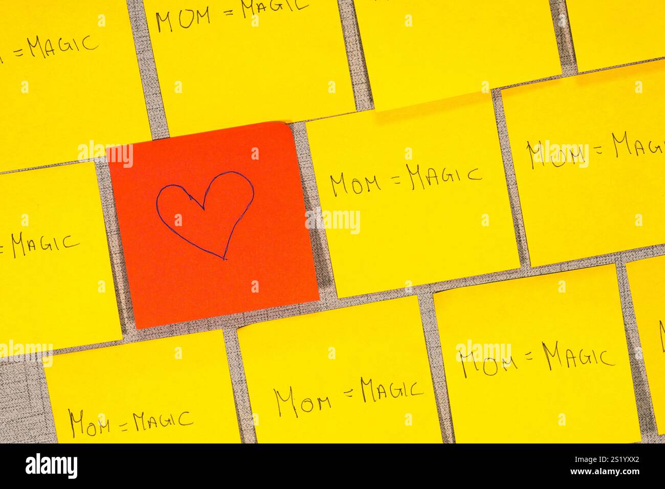 A grey wall with a red note with heart on it. There are many other ...