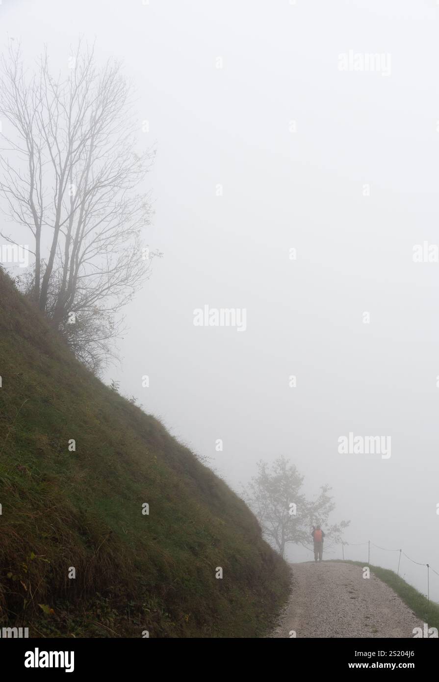 Hiker walking on a foggy mountain path Stock Photo - Alamy