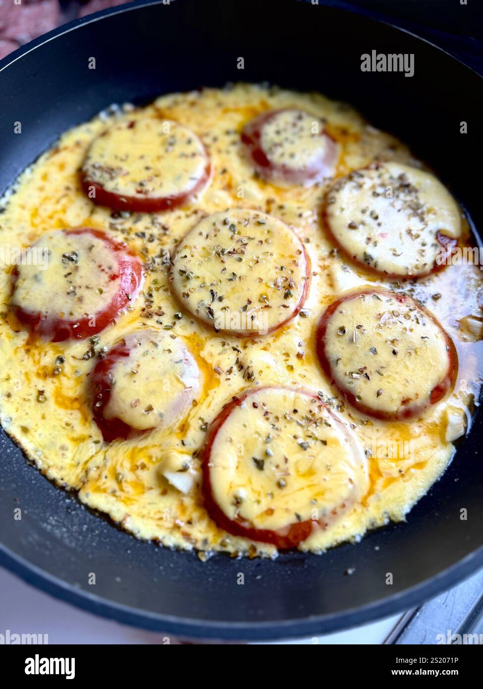 Fried tomatoes and cheddar cheese garlic in pan Stock Photo - Alamy