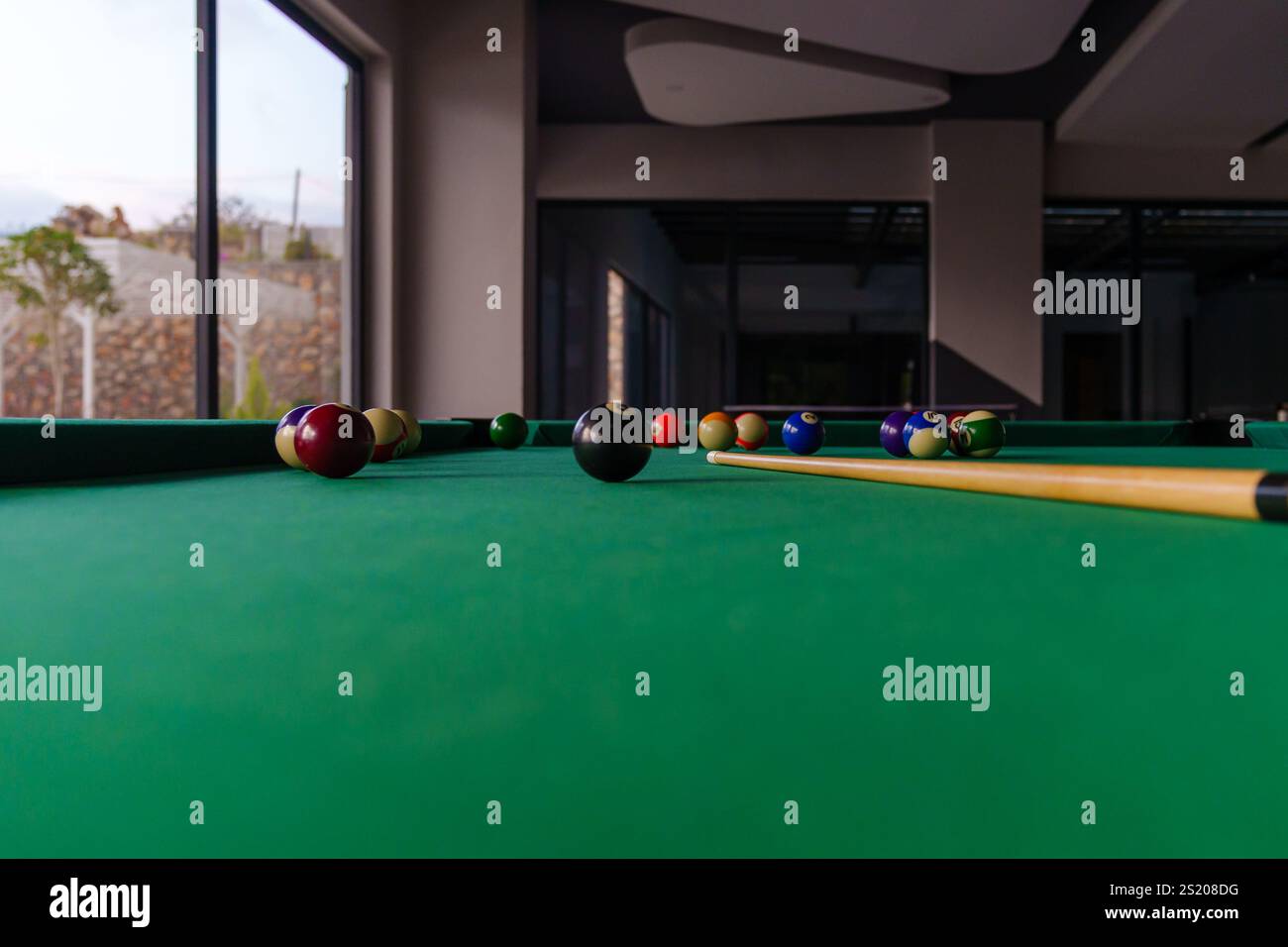 A close-up shot of a pool table highlighting an eight ball in focus ...