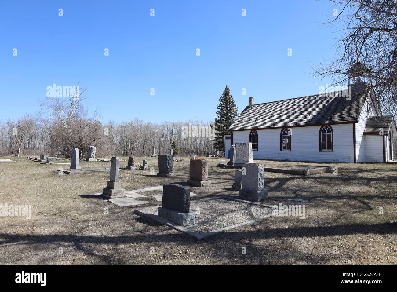 small rural historic church and cemetery under cloudless blue skies ...