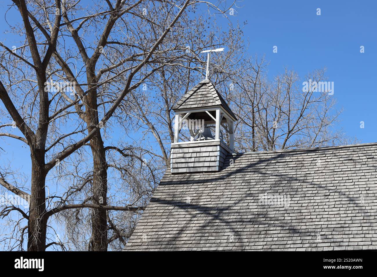 small bell tower on a rural historic church under cloudless blue skies ...