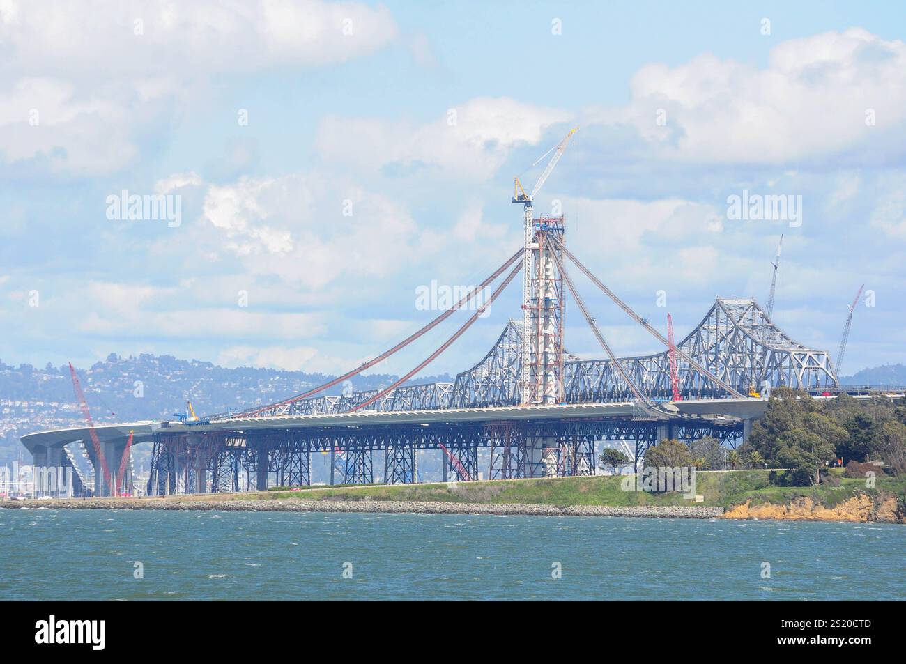 San Francisco Bay Bridge under construction with hills and clouds ...