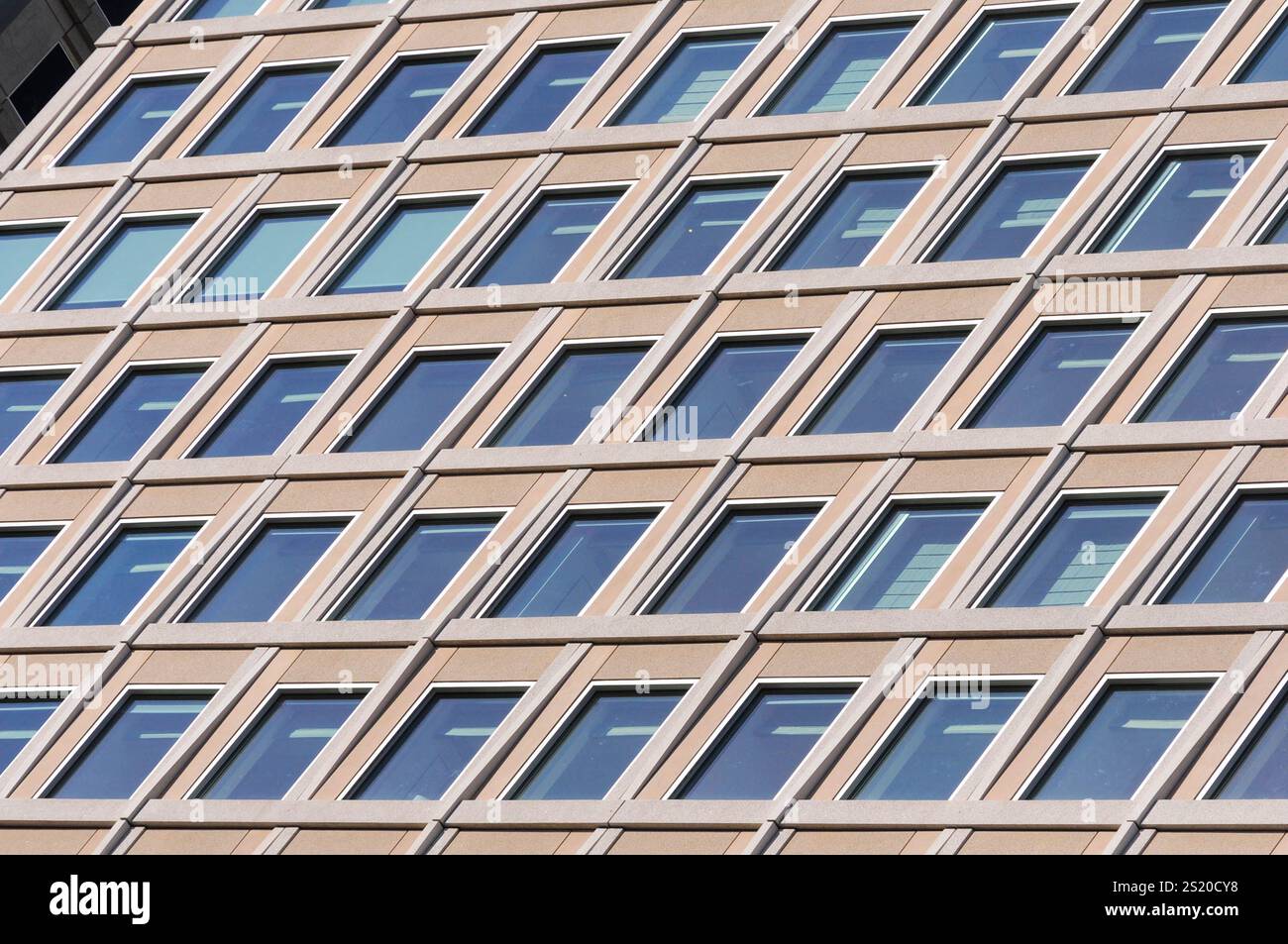 Urban building facade with repeating window patterns in afternoon sky ...