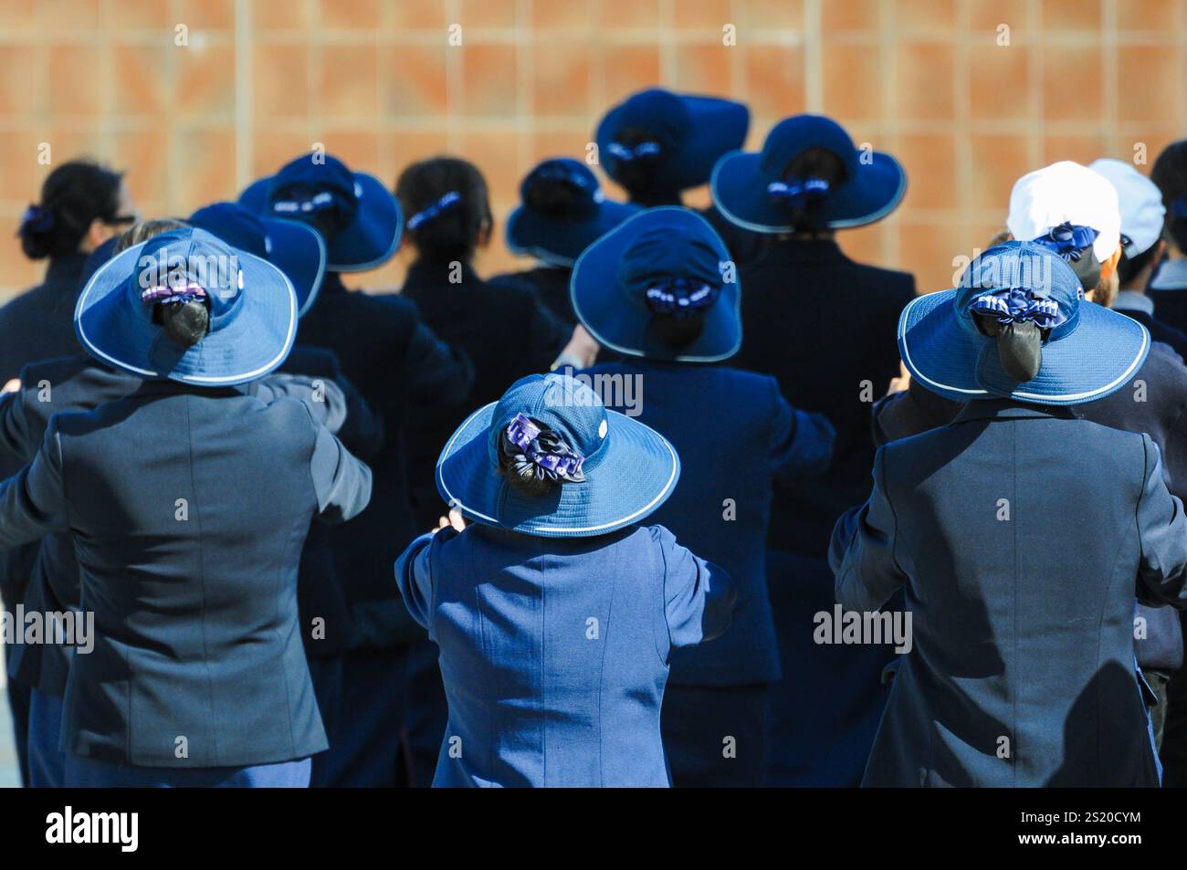 Women in blue uniforms and hats stand in formation, showing unity and ...
