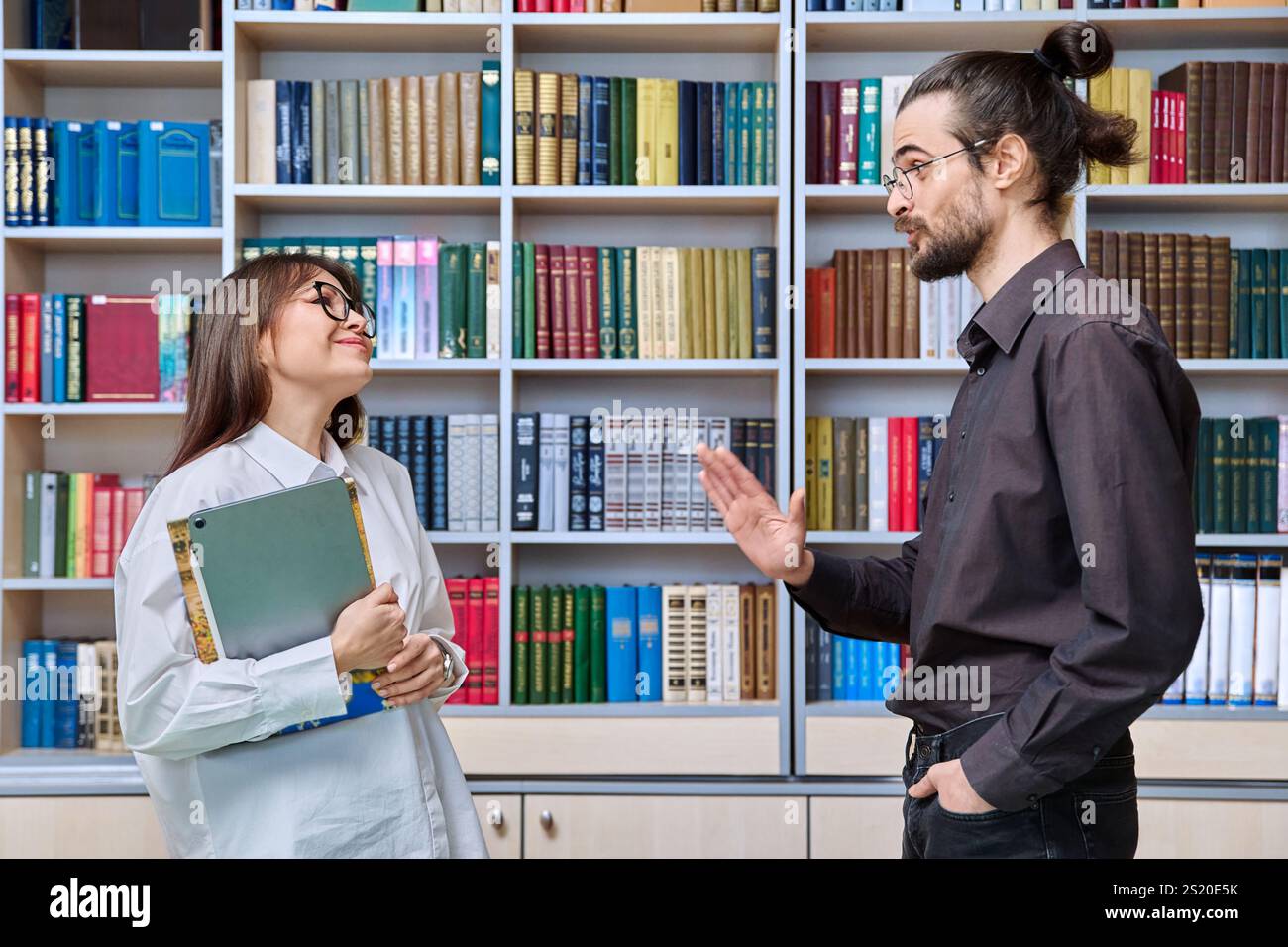 Portrait of man and woman colleagues educators teachers talking inside ...