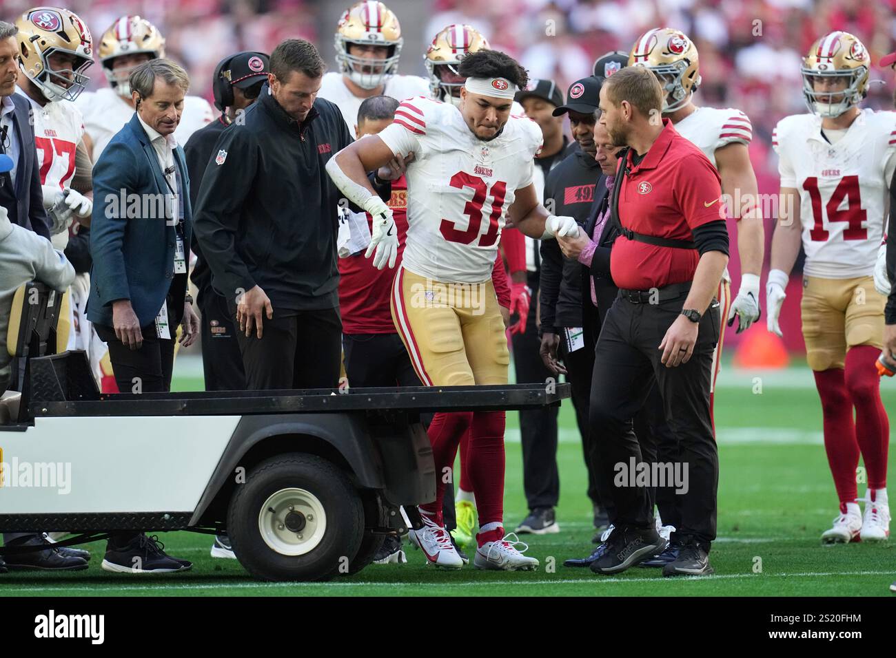 San Francisco 49ers running back Isaac Guerendo (31) is helped onto a ...