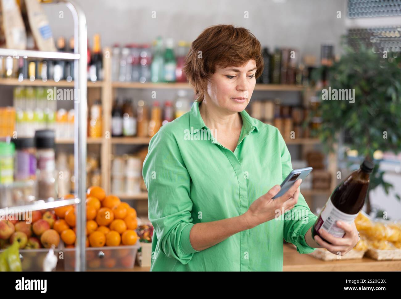 Female shopper scans a QR code on a pomegranate juice label using ...
