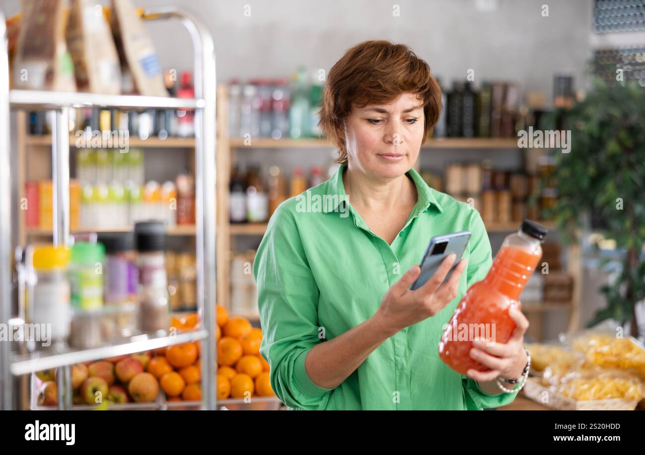 Adult woman scanning qr code of grapefruit juice Stock Photo - Alamy