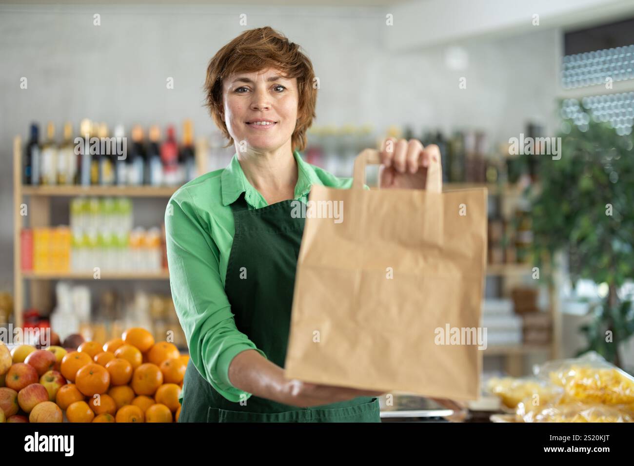 Woman seller stands in trading hall of store with goods in hand Stock ...