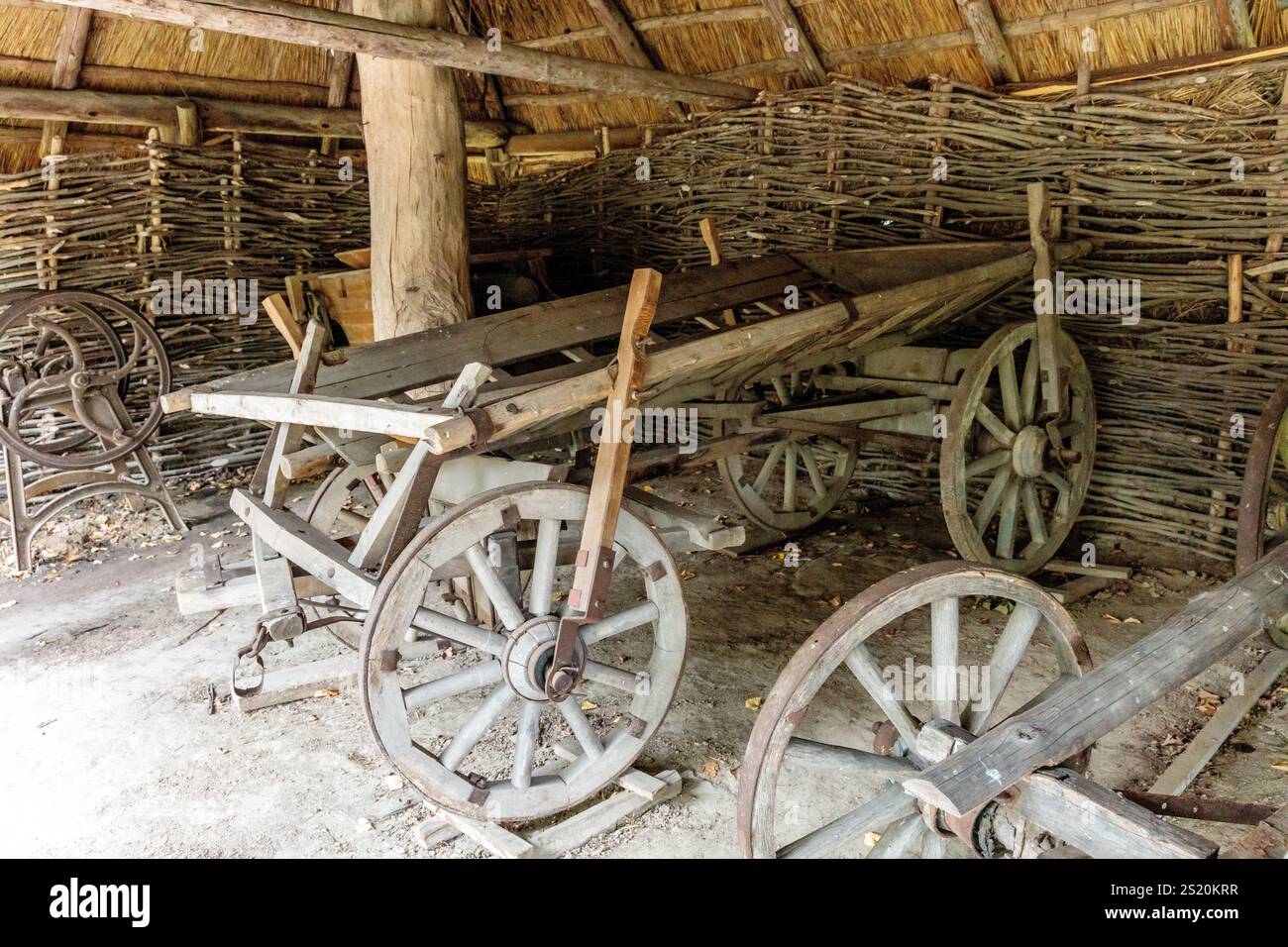 A barn full of old wooden wheels and wagons. Scene is nostalgic and ...