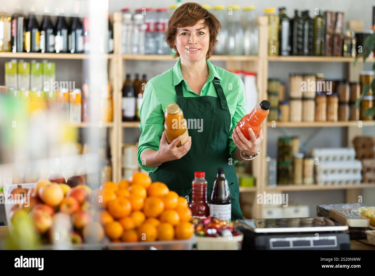 Woman seller stands in trading hall of store with goods in hand Stock ...