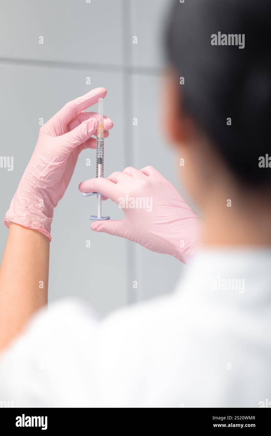 Anonymous female cosmetologist holding injection syringe in clinic ...