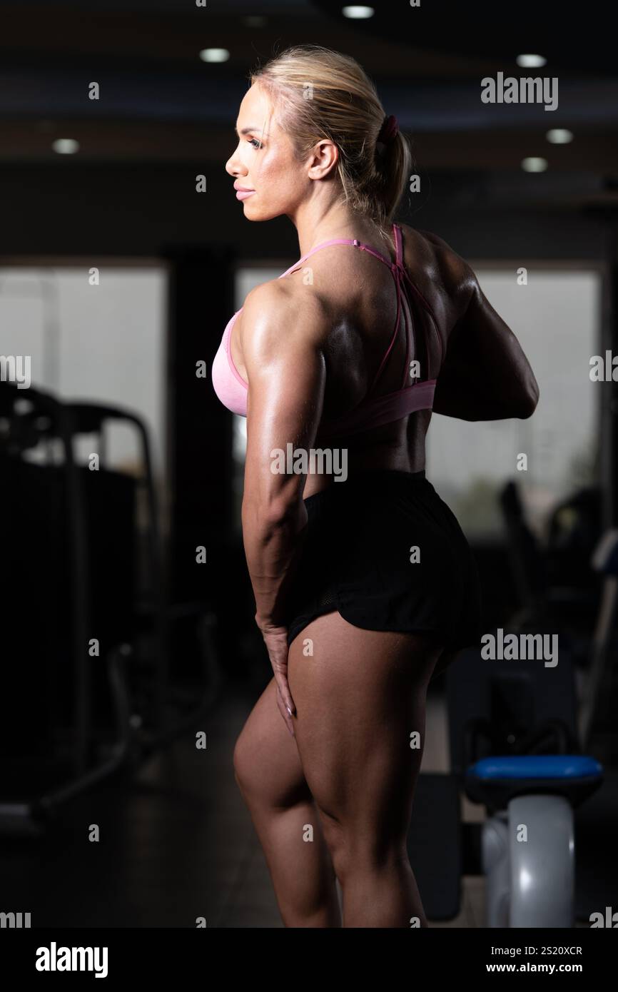 Blonde Woman Posing In A Dark Gym - Perfectly Lit To Showcase Her Toned Muscles And Athletic ...