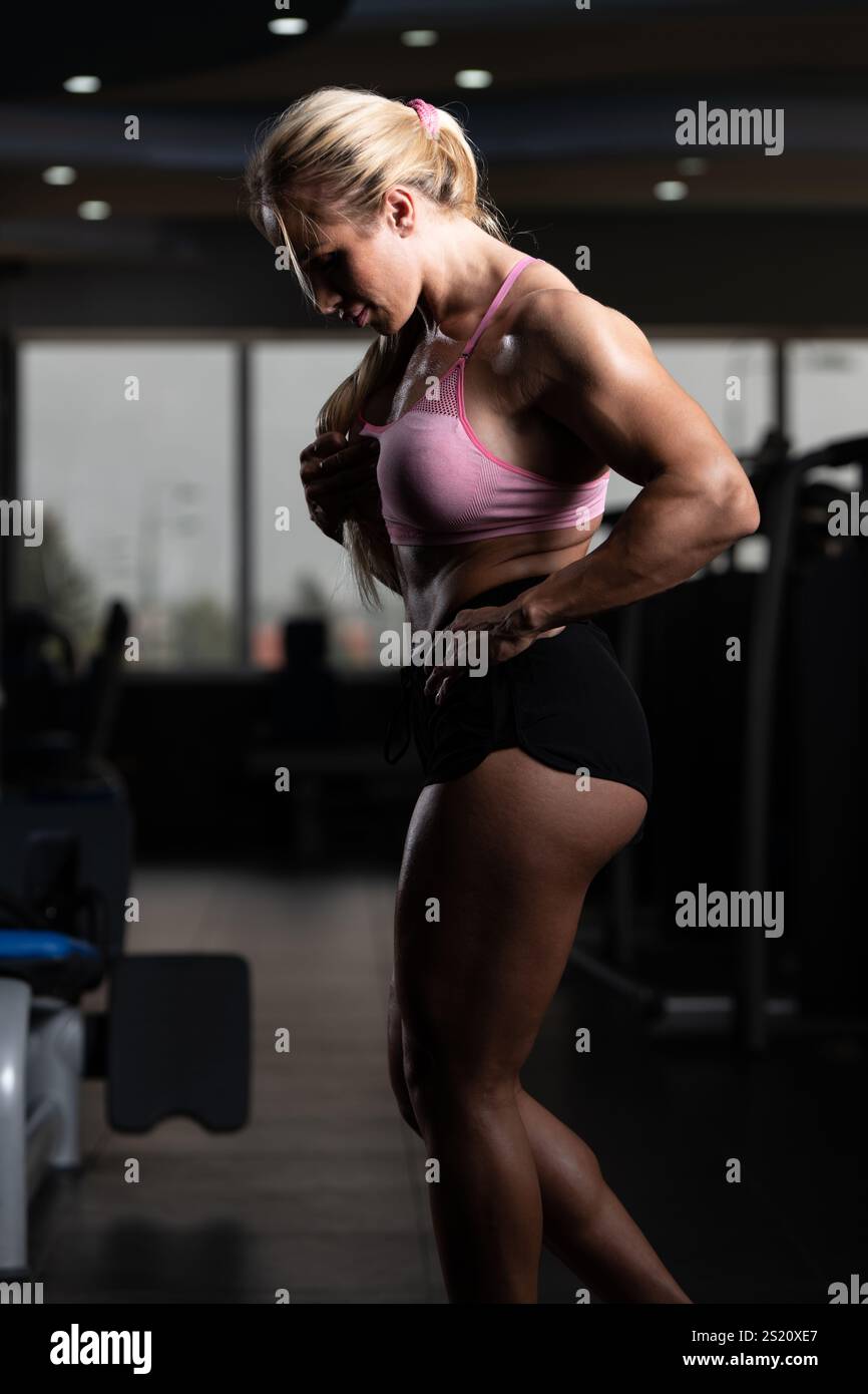 Fit Blonde Woman Striking Poses In A Gym - Showcasing Her Defined Muscles And Confident Energy ...