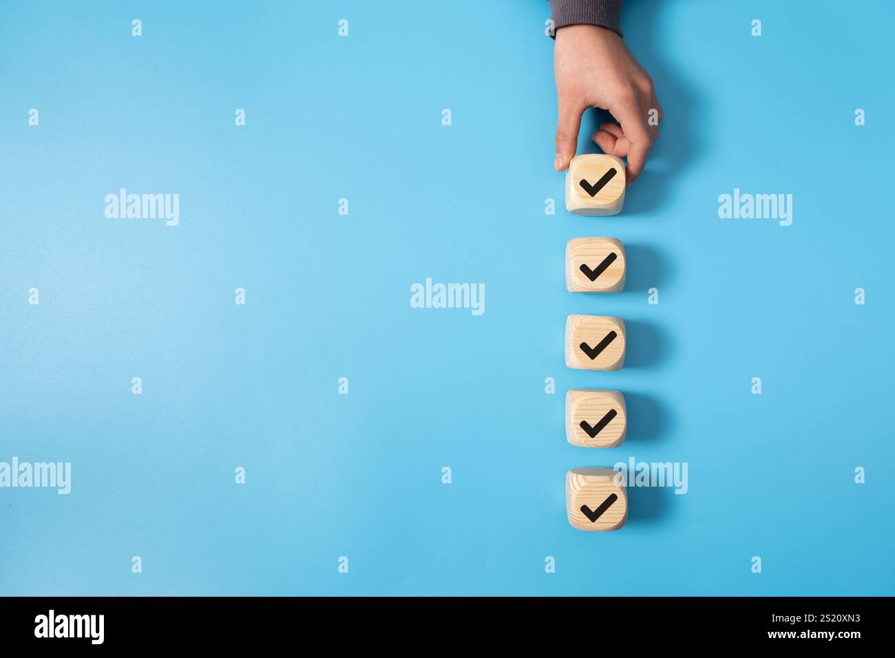 Wooden blocks with checkmarks arranged in a vertical line, symbolizing ...