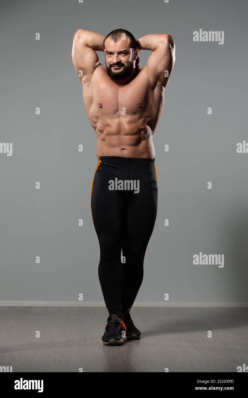 Man Flexing Muscles In Studio With Grey Background Stock Photo - Alamy