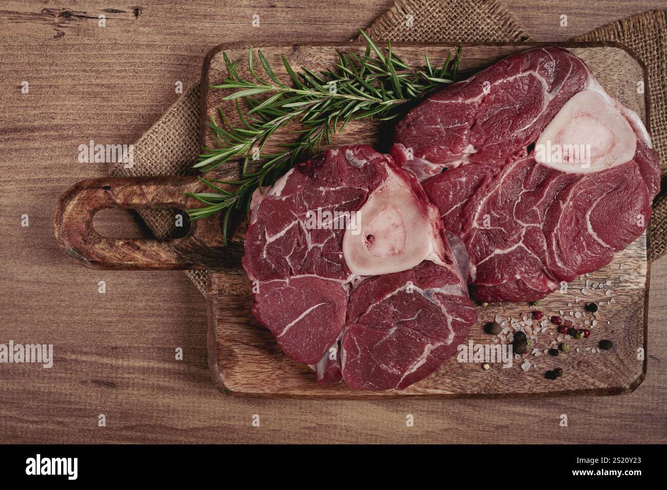 Knuckle on the bone, raw meat for ossobuco, on a wooden chopping board ...