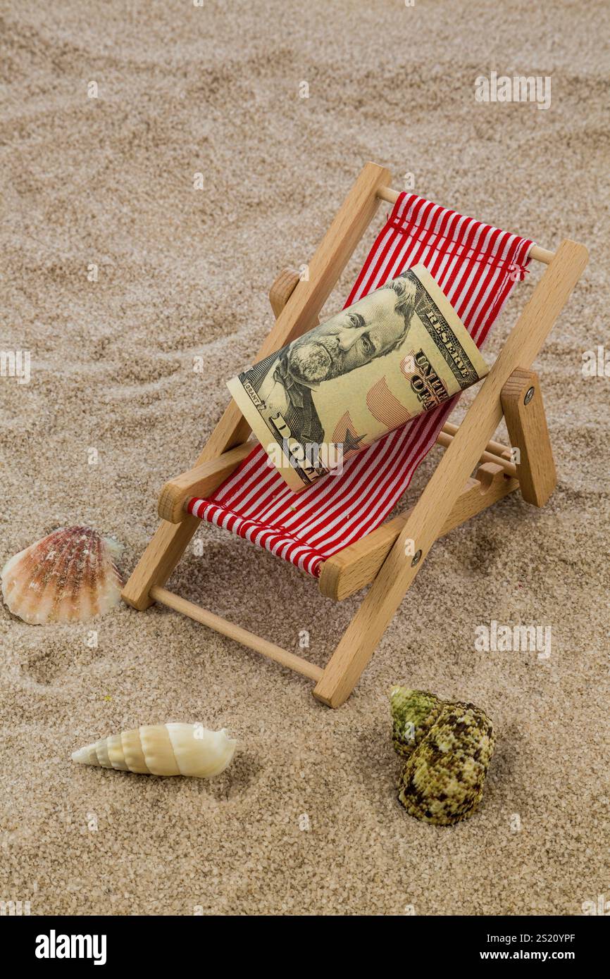 Deckchair with a dollar on a sandy beach. Symbol photo for costs for ...