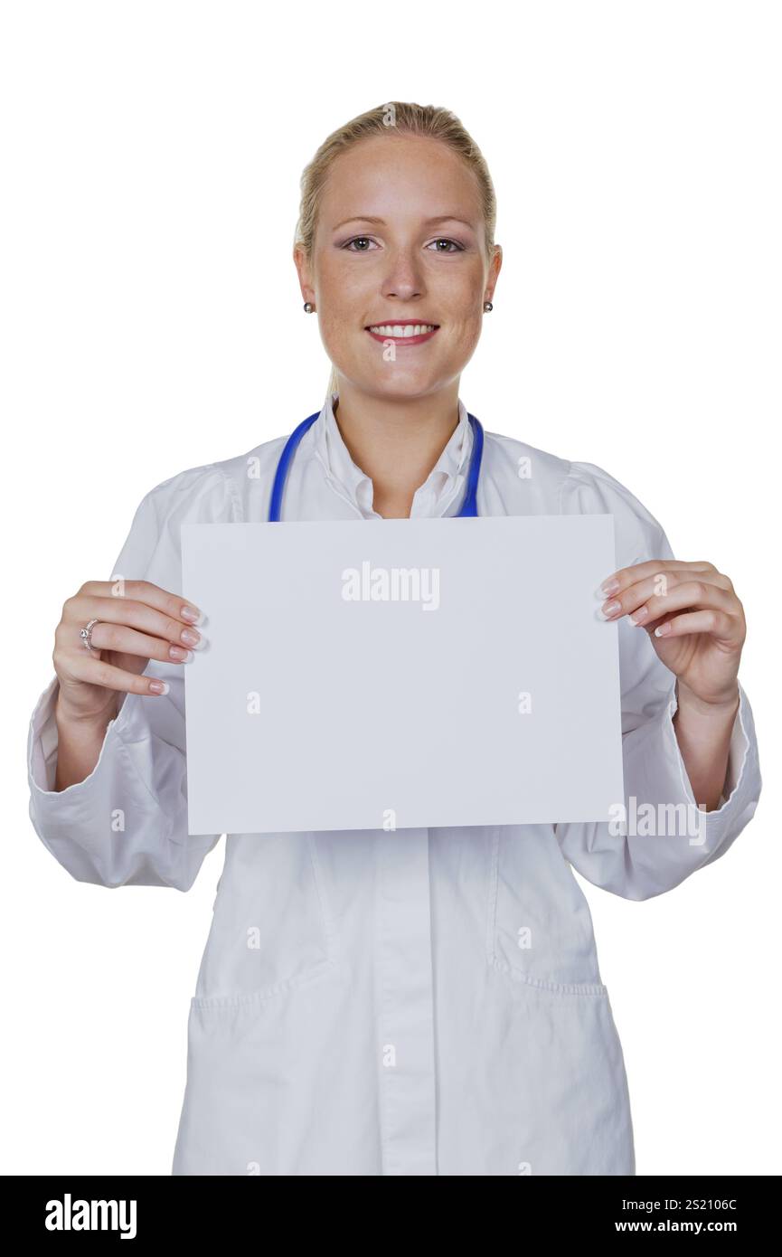 A young doctor with a stethoscope in her surgery. Holds a blank sign in ...