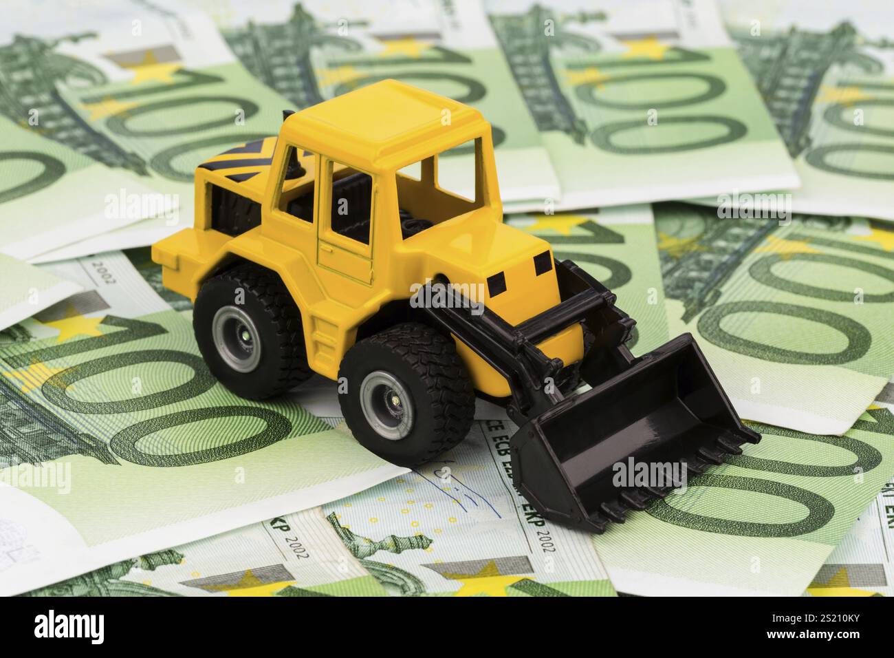 An excavator stands on euro banknotes. Symbol photo for costs, income ...