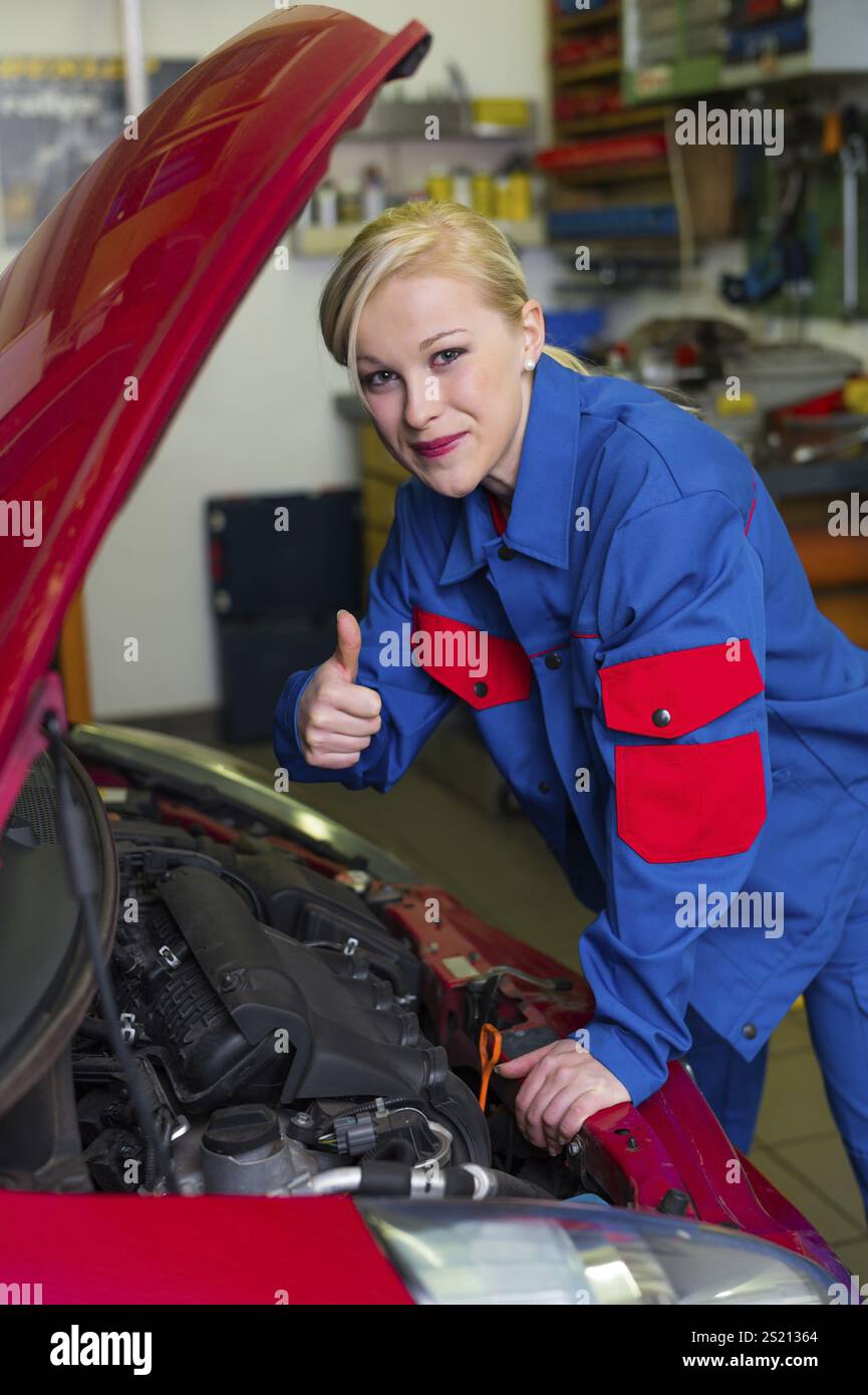 A young woman working as a mechanic in a car repair shop. Rare ...