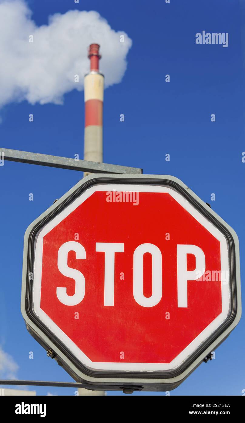 Chimney of an industrial plant and stop sign. Symbolic photo for ...