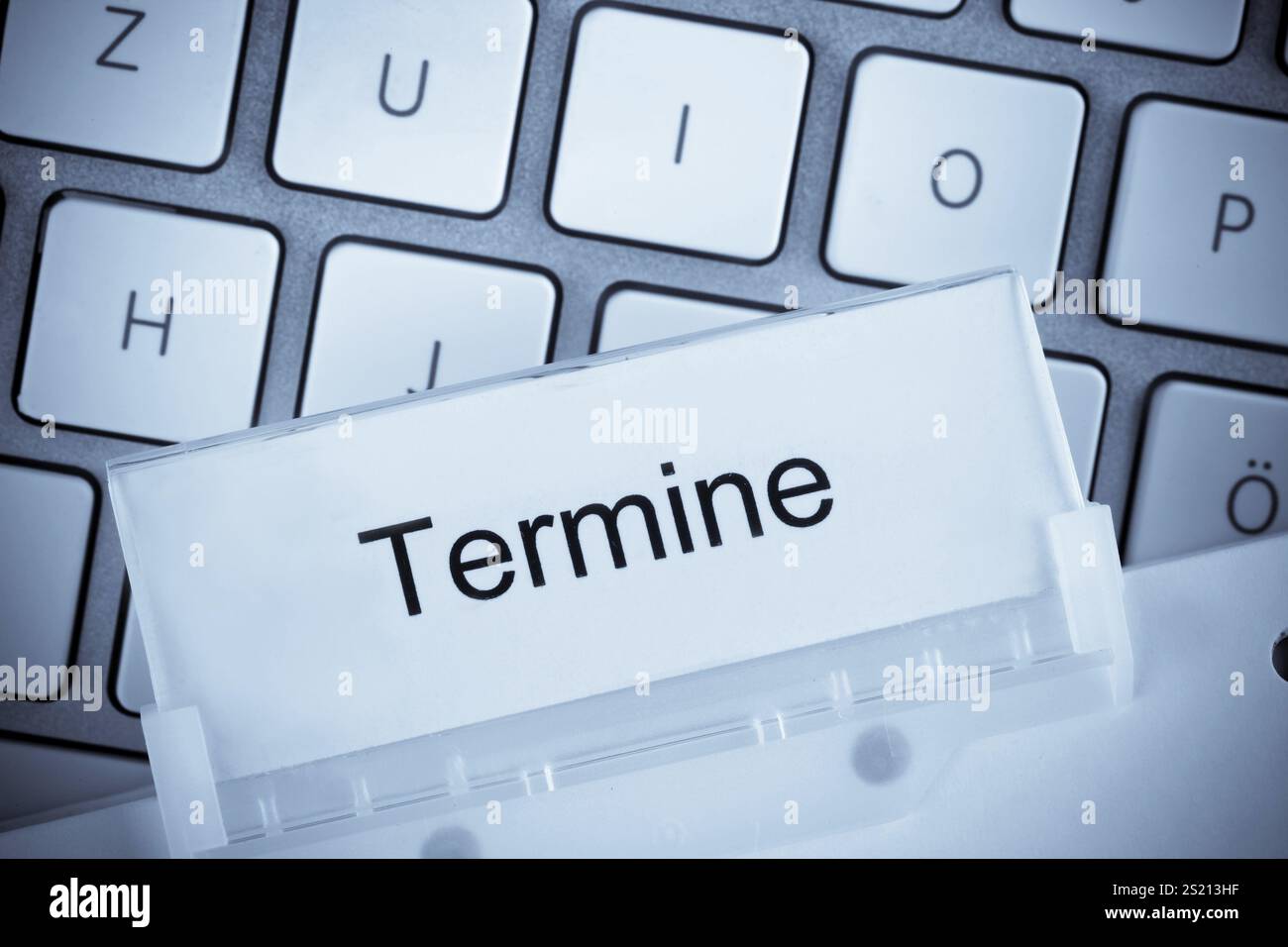 The folder of a hanging file in front of a computer keyboard on the ...