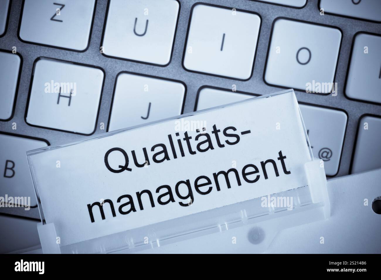 The folder of a hanging file in front of a computer keyboard on the ...