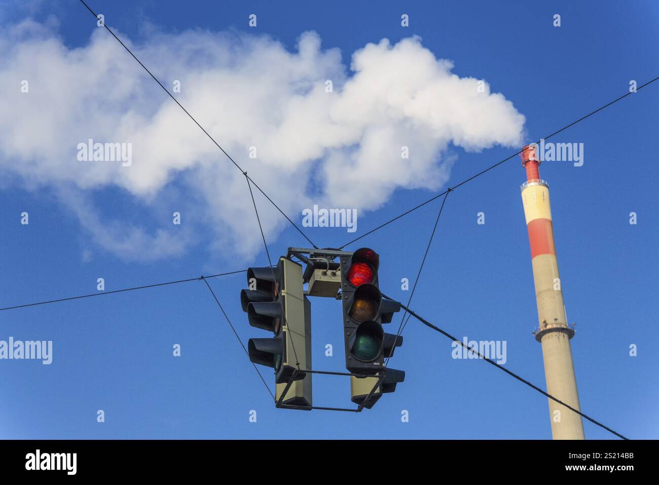 Industrial plant chimney and red traffic light. Symbolic photo for ...