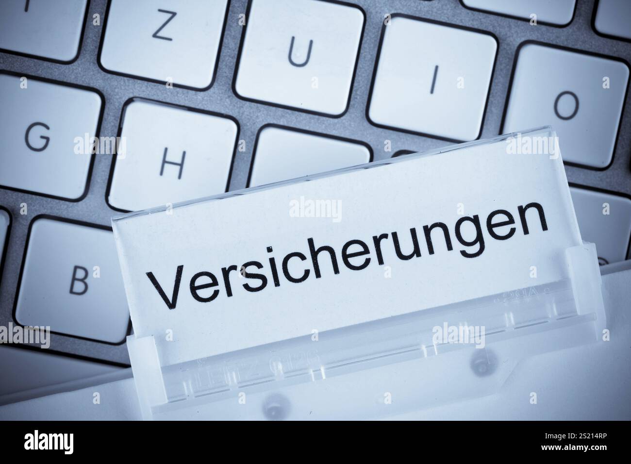 The folder of a hanging file in front of a computer keyboard on the ...