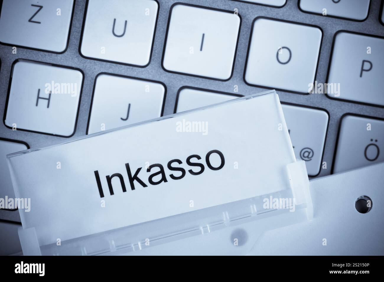 The folder of a hanging file in front of a computer keyboard on the ...