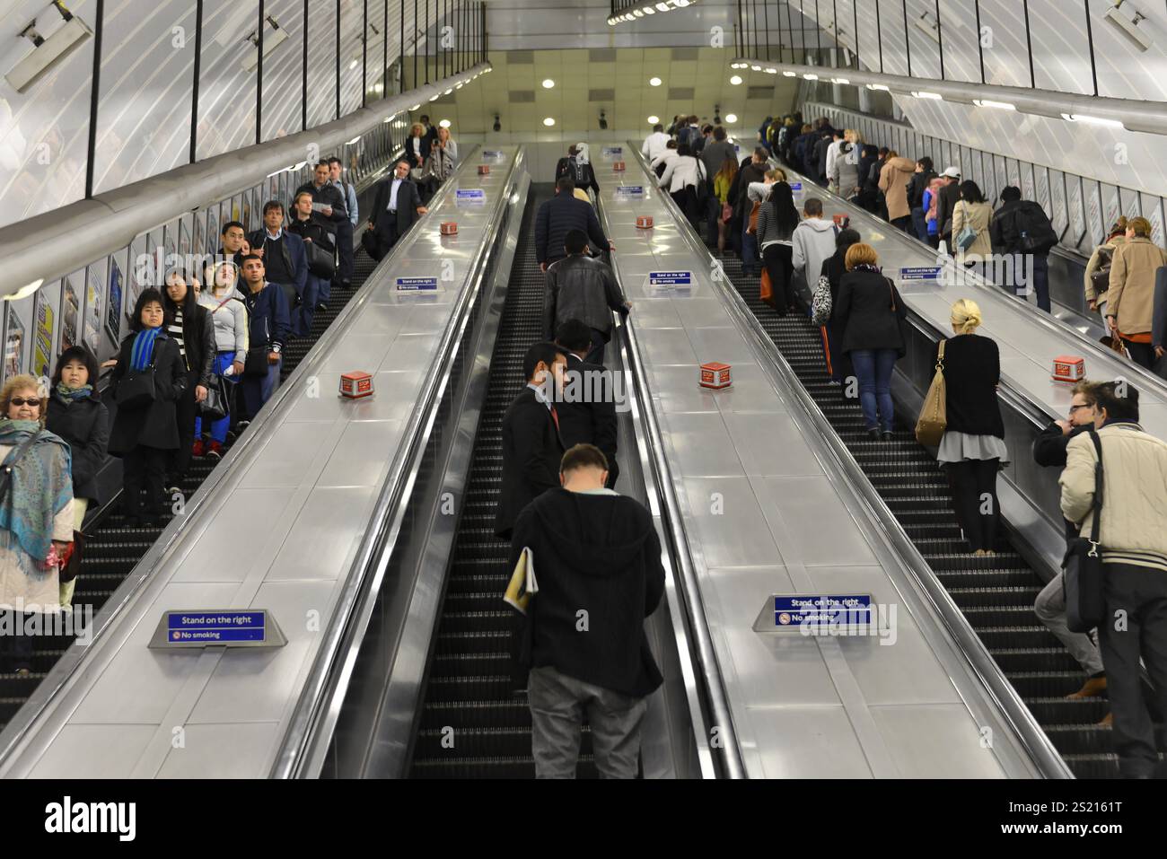 People on wide escalators in an urban underground station, London ...