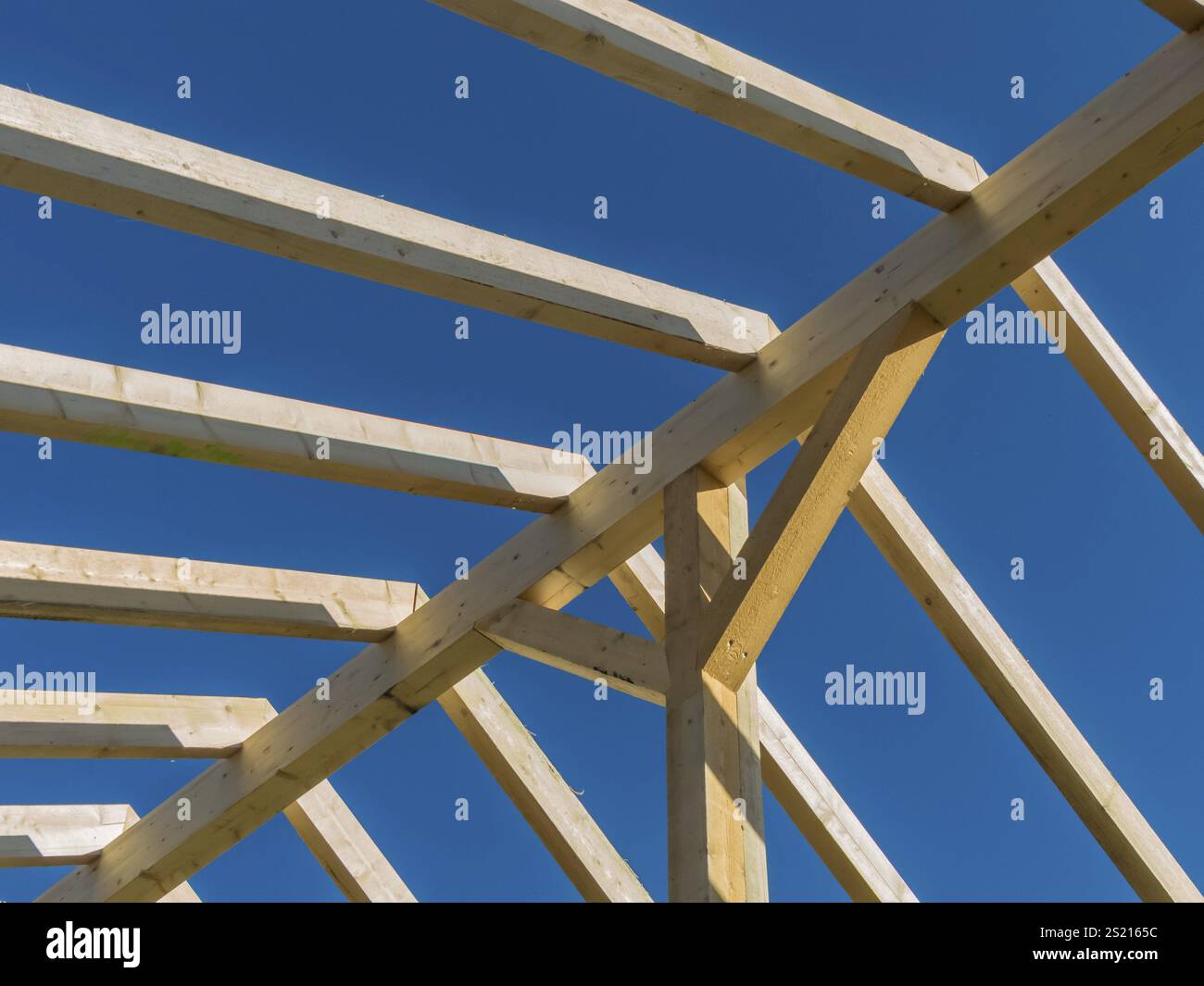 A new roof is being built on a house on a building site. Wooden beams ...
