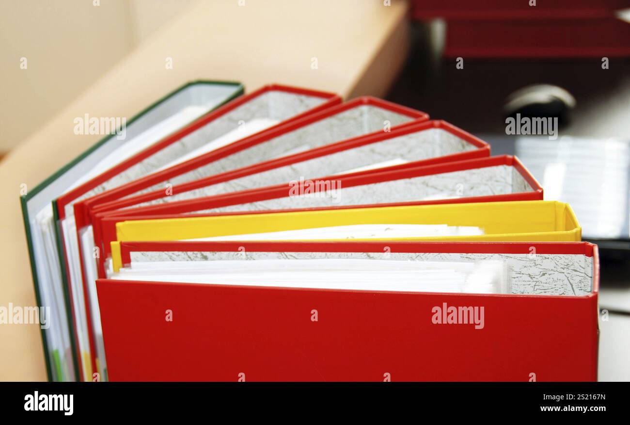 Colourful files with documents on office desk Stock Photo - Alamy