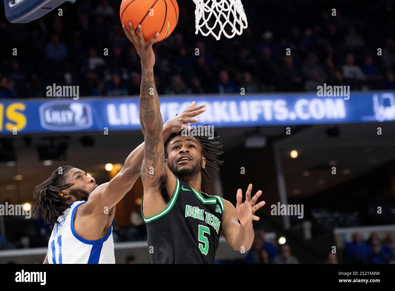 North Texas guard Rondel Walker (5) shoots defended by Memphis guard ...