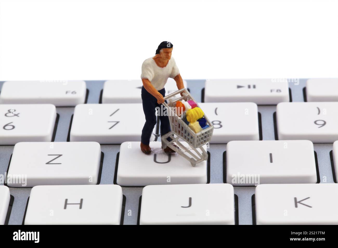A figure with a shopping basket on a computer keyboard. Symbol photo ...
