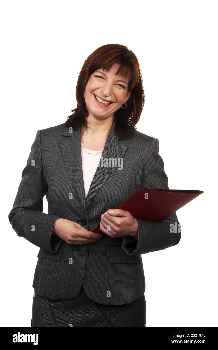 A secretary stands laughing in front of a white background. She is ...