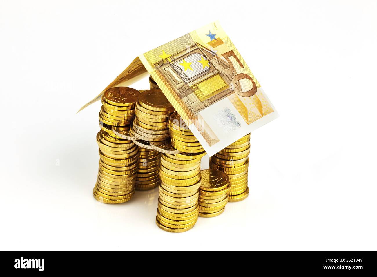 A house made of money coins and banknotes. Symbol photo for house ...