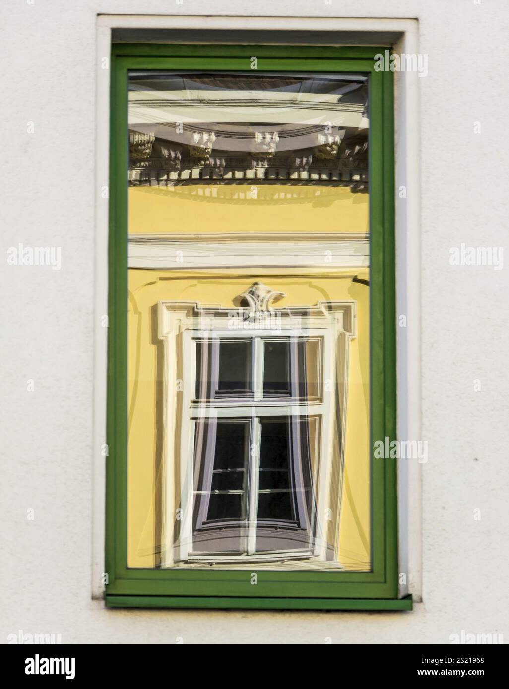 A refurbished residential building is reflected in the modern window of ...