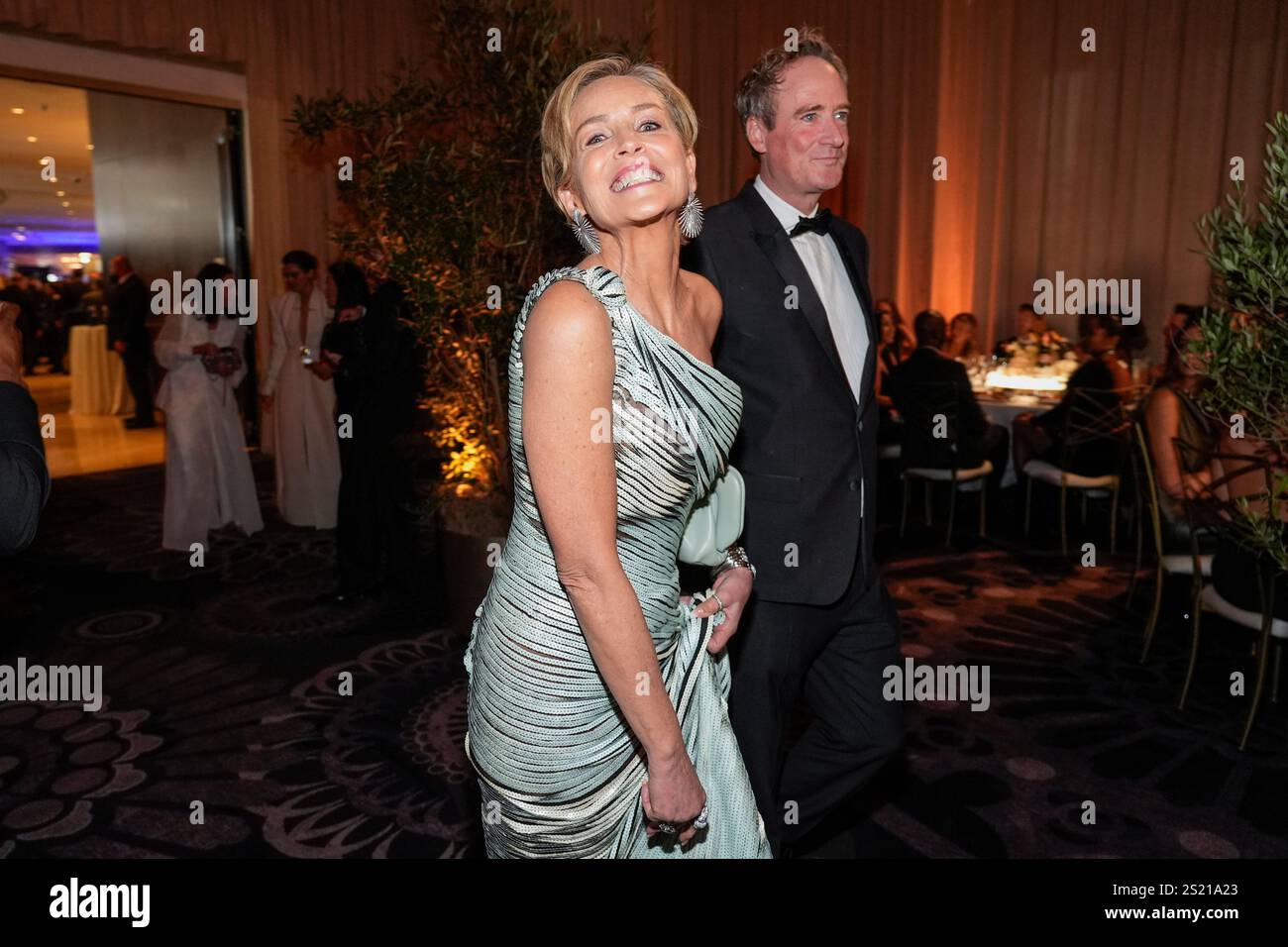 Sharon Stone, left, and Jim Osborne arrive at the 82nd Golden Globes on ...